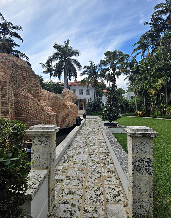 A stone pathway leads visitors on a journey of discovery between sculptural elements and the historic main house.
