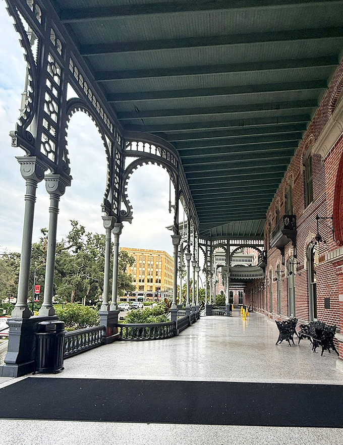 The sweeping veranda wraps around the building like an architectural embrace, its columns and ironwork creating a graceful transition between indoors and out.