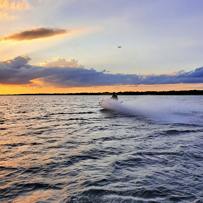 Adrenaline meets golden hour as water sports enthusiasts carve their temporary signatures across the lake's sunset-painted surface.