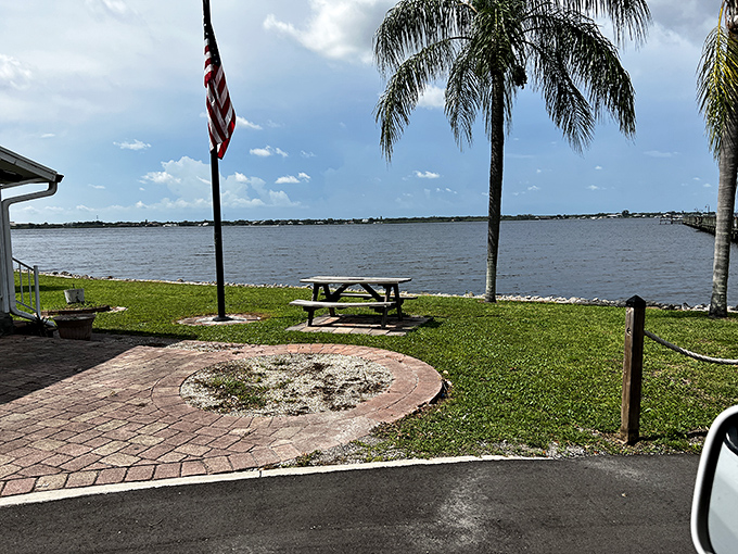 Riverside tranquility just steps from historical significance, where picnic tables invite contemplation of both natural beauty and human history.