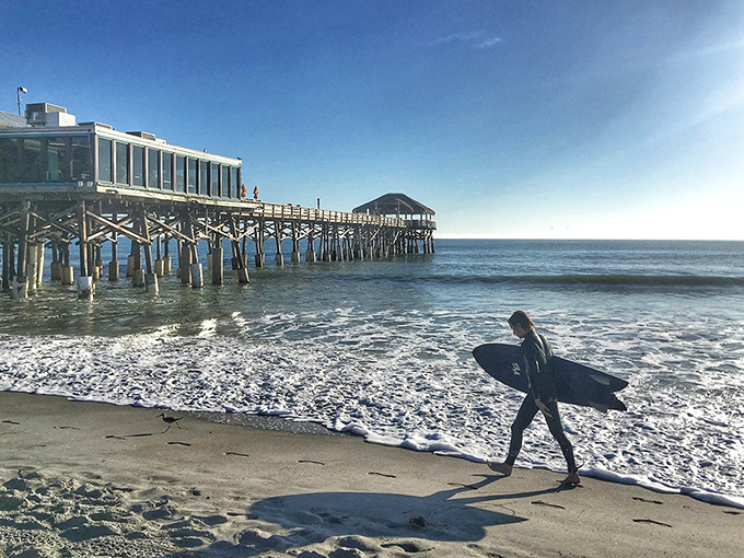 Here comes the intrepid surfer, board in hand, silhouetted against the bright morning light. The ocean is calling, and they must go.