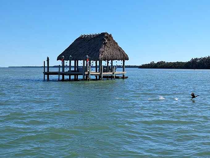 A tiki hut floating on the water like a tropical mirage, proving that sometimes the best beach bars don't serve drinks, just views.