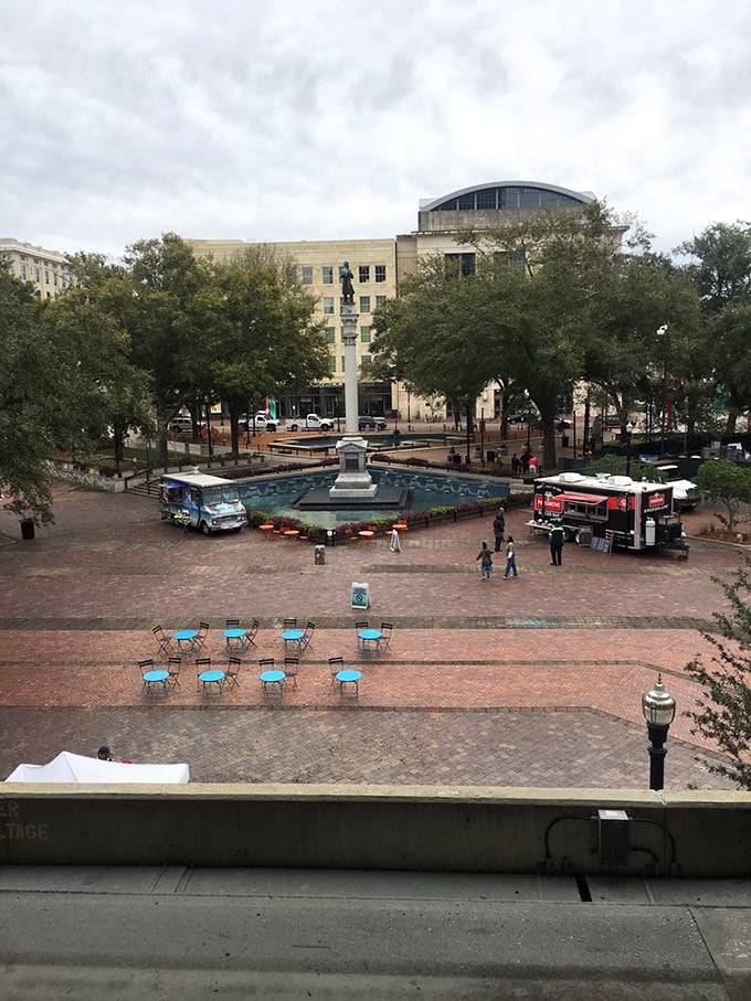 A bird's-eye view reveals the park's layout, with food trucks, seating areas, and the central monument creating a harmonious urban oasis.