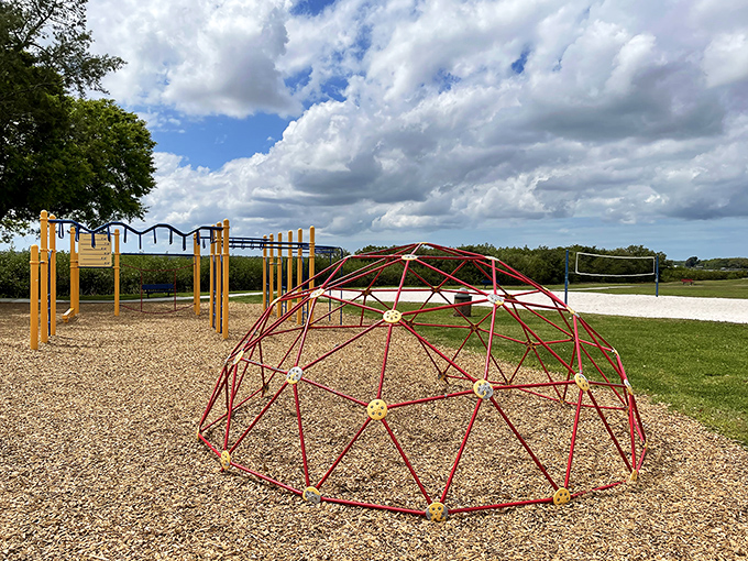 Geometric jungle gym where children navigate metal meridians with the seriousness of mountaineers scaling Everest.