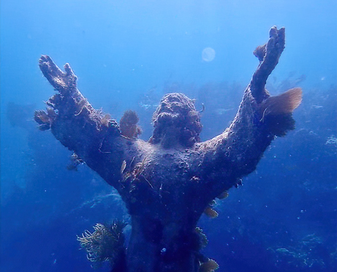 Close inspection reveals the intricate details of the statue's design, now enhanced by nature's own artistic additions of coral and marine growth.