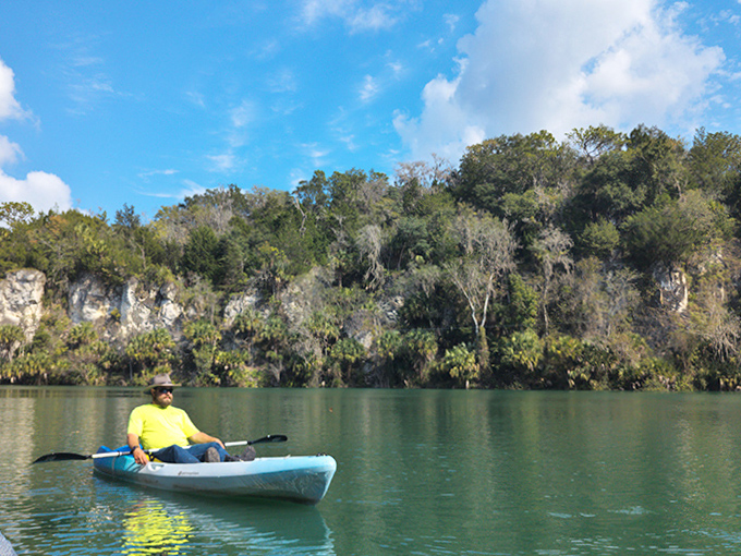 Finding serenity in solitude, a lone explorer drifts across waters that mirror the sky with perfect clarity.