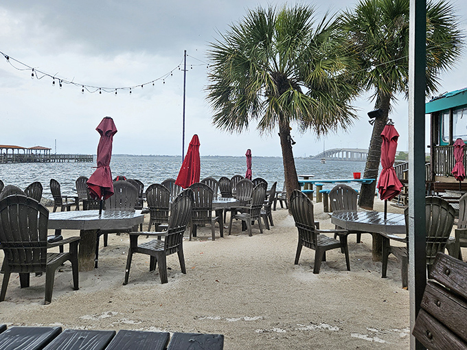 Adirondack chairs face the water, inviting guests to relax over drinks as the sky fills with spectacular Florida colors.