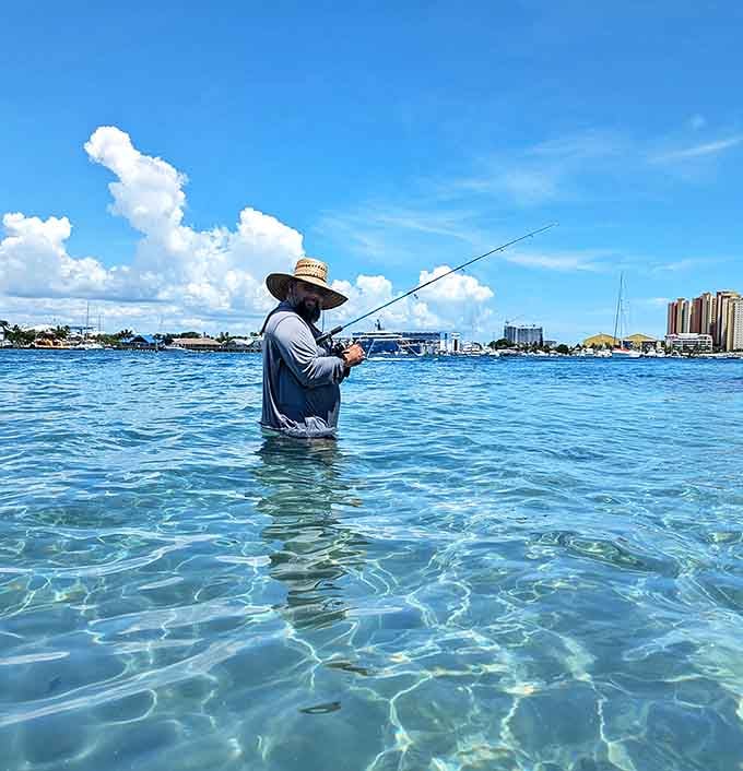Patience pays off for this angler standing thigh-deep in crystal waters, where fishing becomes meditation with spectacular views.