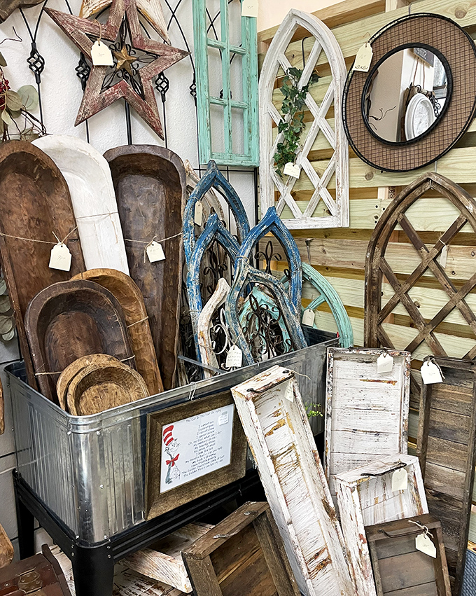 Rustic wooden dough bowls and architectural salvage lean casually against weathered windows, offering farmhouse charm for modern homes seeking authenticity.