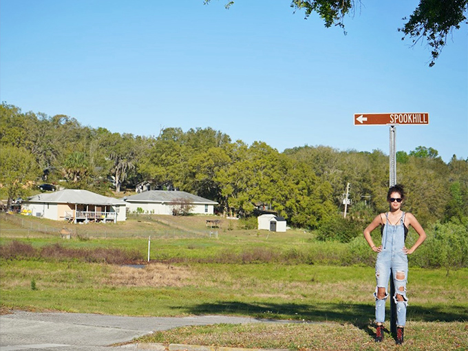 Spook Hill's directional sign stands sentinel in the Florida sunshine, guiding curious travelers to one of the state's most beloved roadside attractions.