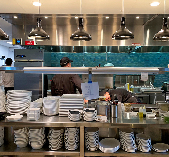 The kitchen team works with precision behind the scenes, transforming local ingredients into memorable dining experiences.