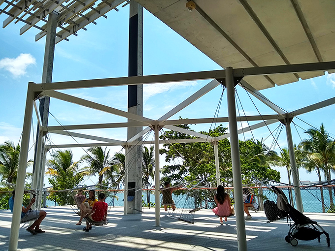The waterfront terrace invites contemplation and conversation, where swings turn adults back into children under Miami's impossibly blue sky.
