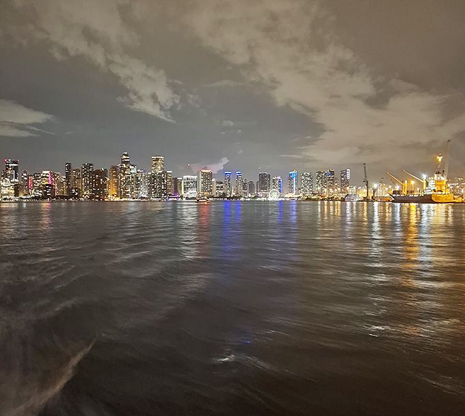 As night falls, Miami's skyline glitters in the distance, a modern counterpoint to Stiltsville's old-world simplicity just a few miles offshore.