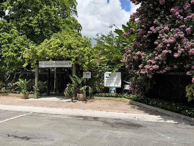 The garden entrance beckons with tropical abundance, a threshold between ordinary life and botanical wonderland waiting just beyond.