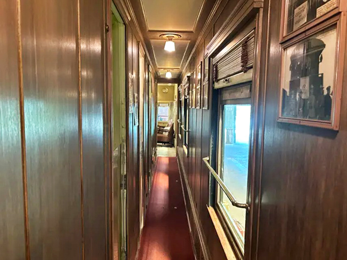The narrow hallway connected the car's compartments, its polished wood paneling reflecting the soft glow of overhead lights.
