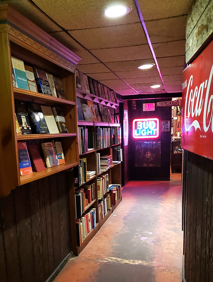 Even the hallway to the restrooms continues the literary theme, with bookshelves lining the walls and neon signs adding a warm glow.