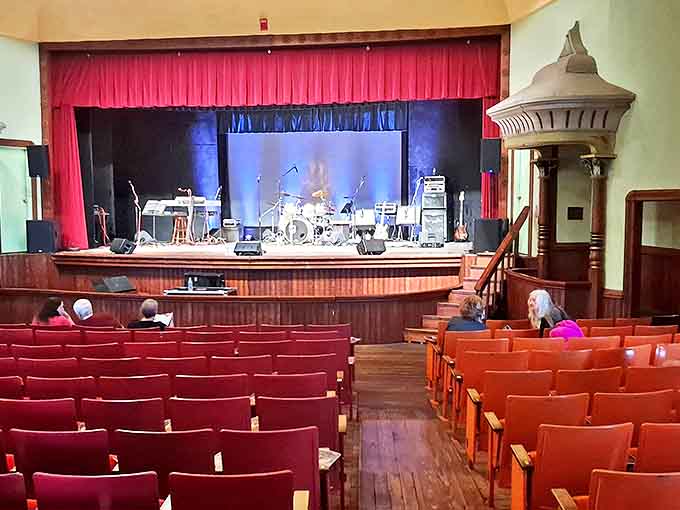 The empty theater awaits its audience, musical instruments standing ready on stage for an evening of acoustic perfection in this historic space.