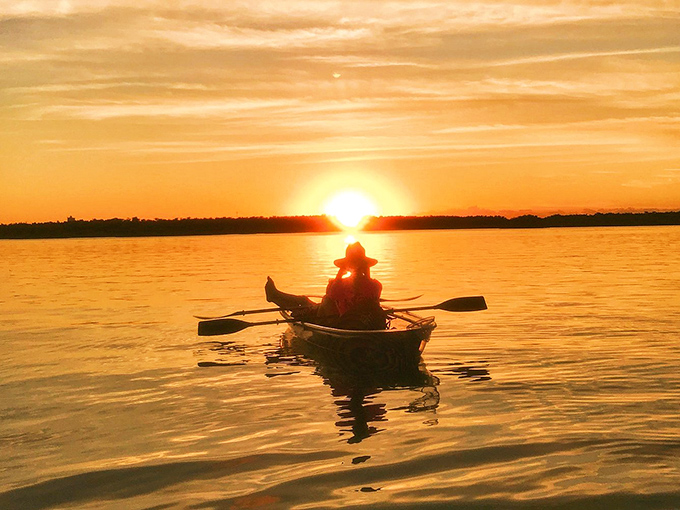 A lone kayaker paddles into the sunset, creating the kind of moment that belongs on a postcard or your phone's wallpaper.