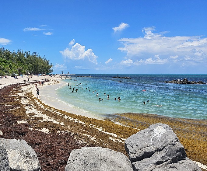 Beachgoers cool off in the refreshing waters, finding relief from the Florida heat in nature's own air conditioning system.