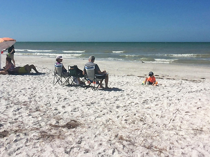 Beach chairs and umbrellas dot the shoreline like colorful confetti, each representing a day of vacation perfection.