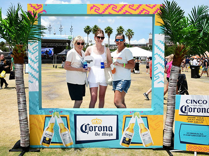 Festival-goers pose in a colorful photo frame during Tampa Riverfest, capturing memories of this waterfront celebration.