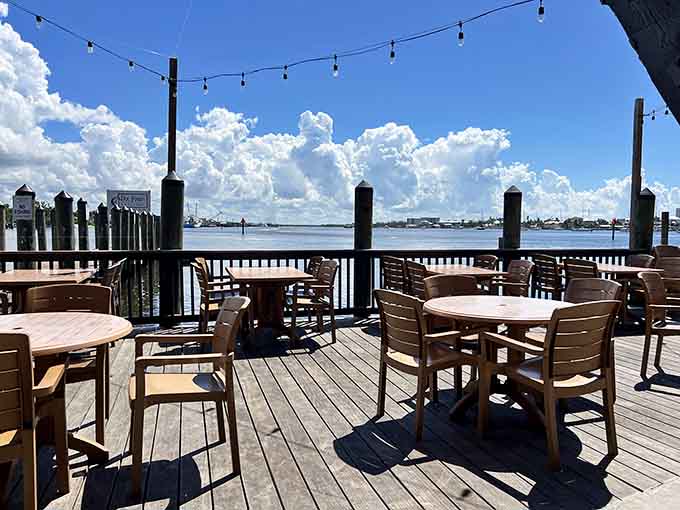 The waterfront deck under string lights transforms dinner into an experience, with boats drifting by and breezes off the water.