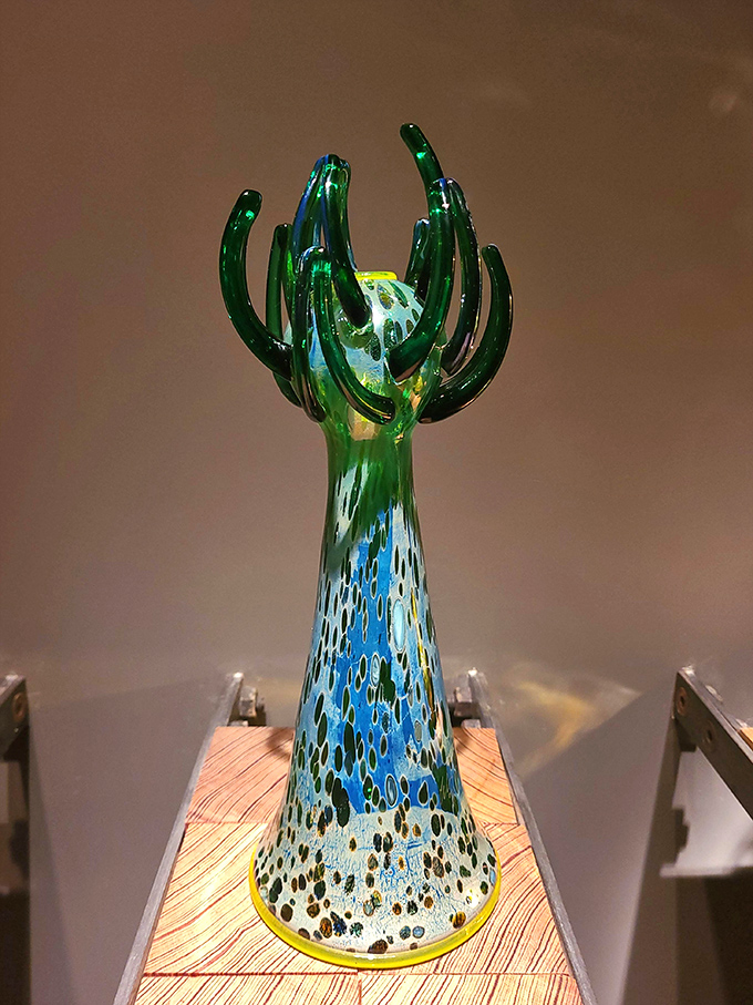 This blue-green sculpture rises like a fantastical plant from an alien shore, its tentacle-like extensions reaching toward invisible light.
