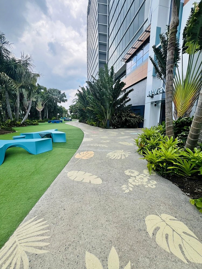 The path to Haven features tropical leaf imprints in concrete, creating a subtle artistic transition between garden and architecture.