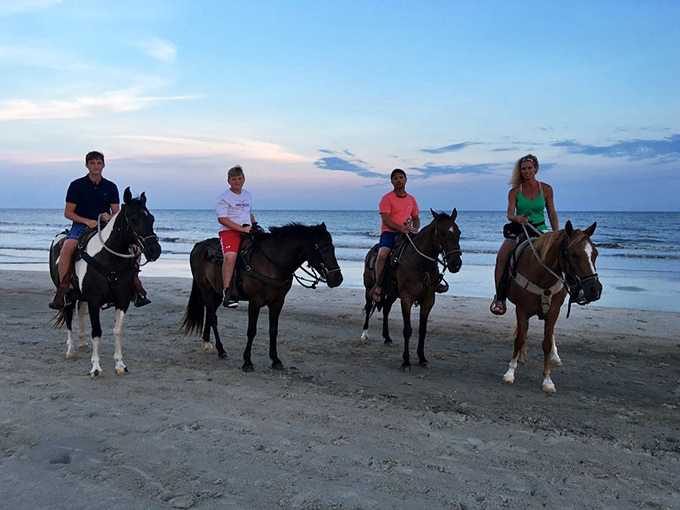 Horseback riders create postcard-perfect moments, their silhouettes etched against the shoreline as hooves splash through gentle surf.