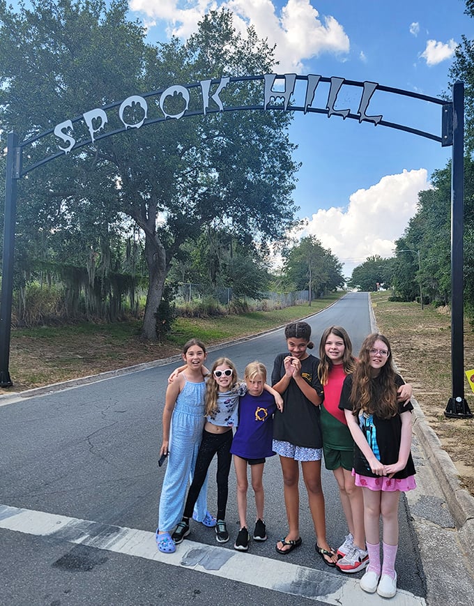 Young explorers gather under the Spook Hill sign, about to experience the same wonder that's delighted visitors for decades.