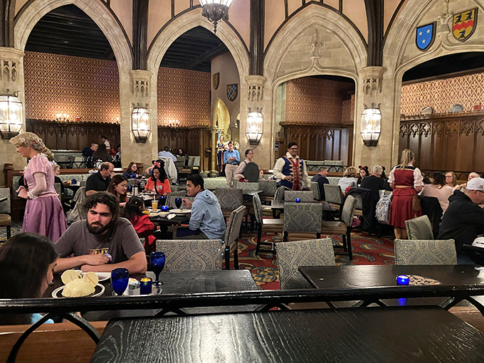 The bustling banquet hall buzzes with excitement as royal servers attend to guests while princesses make their grand entrances.