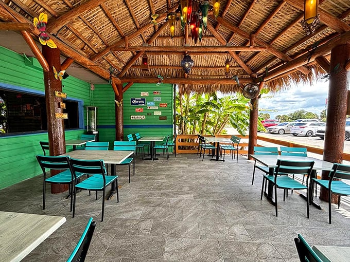 The thatched-roof patio offers a tropical escape&mdash;turquoise chairs and wooden posts create a casual oasis for outdoor dining.