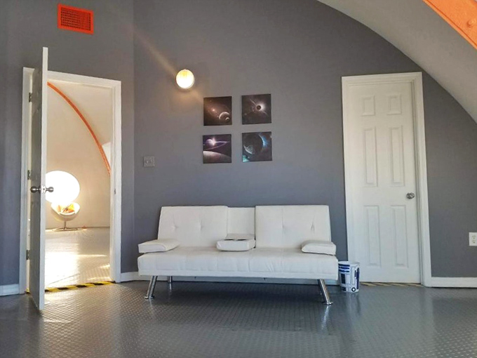 The seating area features mod furniture and pops of orange that would make any 1960s space program designer nod with serious approval.