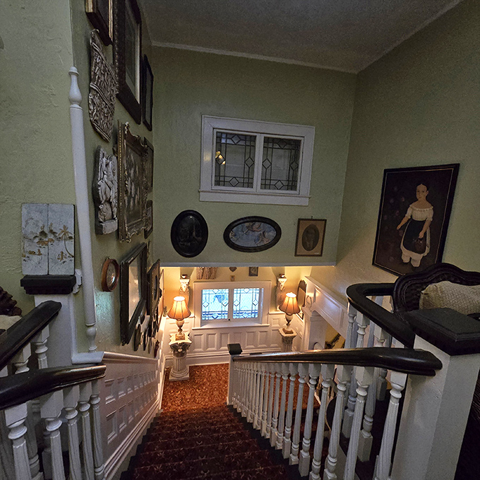 The grand staircase, lined with vintage portraits and illuminated by soft lamplight, invites guests upward&mdash;though some report hearing footsteps when no one's there.