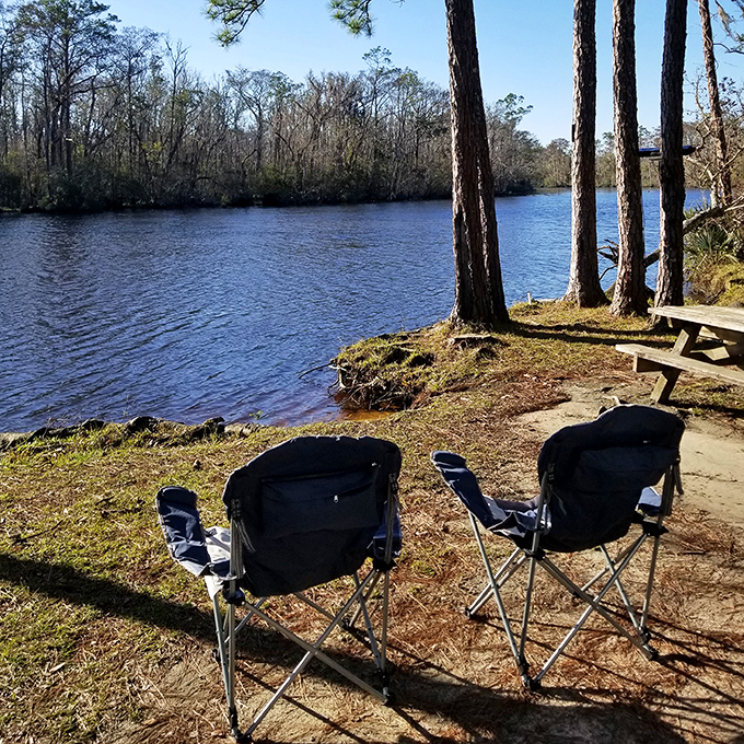 Two empty chairs await storytellers by the water's edge &ndash; the perfect spot to recount the day's adventures as fish jump nearby.