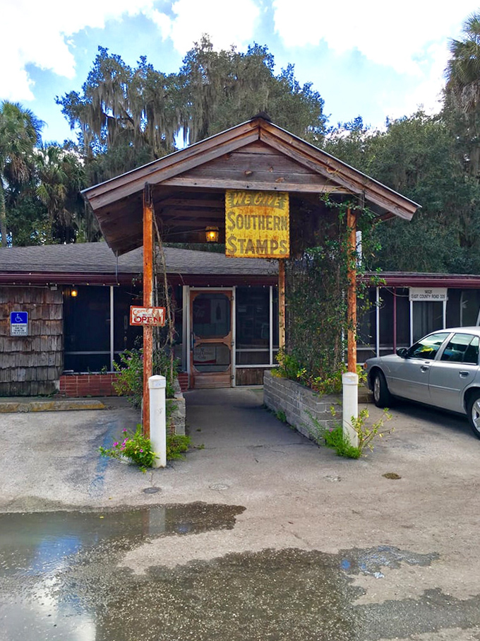 This weathered entrance has welcomed hungry travelers for decades, its vine-covered posts standing sentinel like old Florida cypress knees.