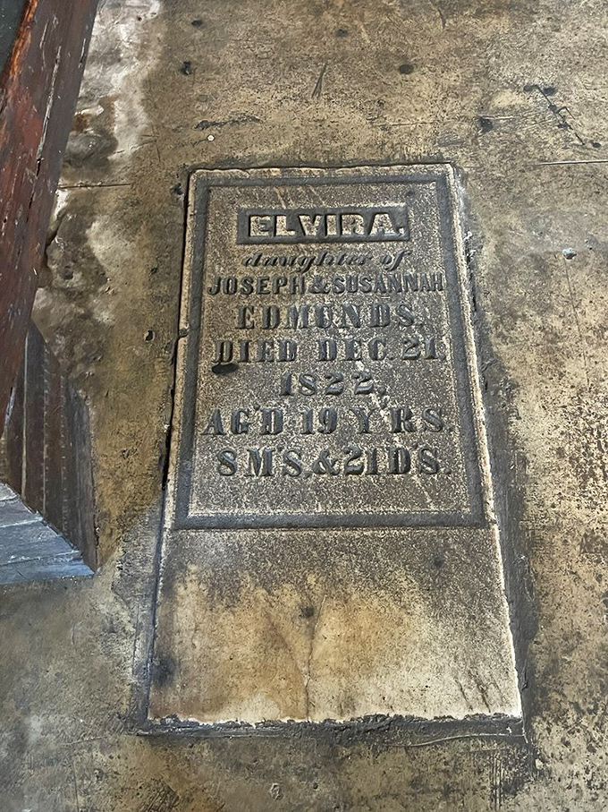 Elvira's grave marker embedded in the floor &ndash; a somber reminder to live fully while you can, preferably with a good drink in hand.