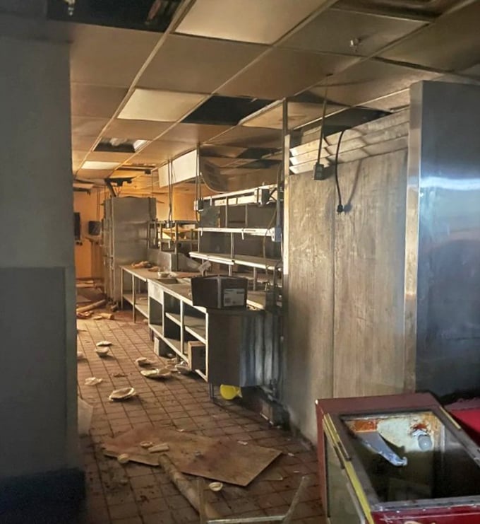 The kitchen's stainless steel surfaces reflect nothing but abandonment, though they're surprisingly resistant to the apocalypse &ndash; unlike the ceiling.