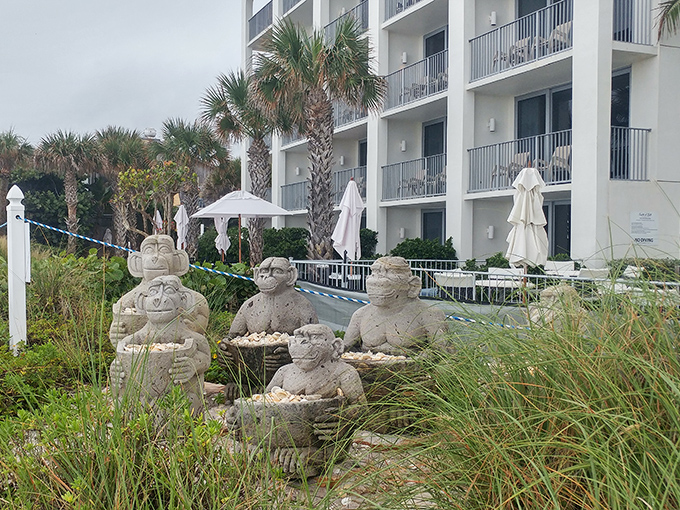 Whimsical stone figures stand guard in the coastal garden, offering silent welcome to guests as they approach this culinary sanctuary.