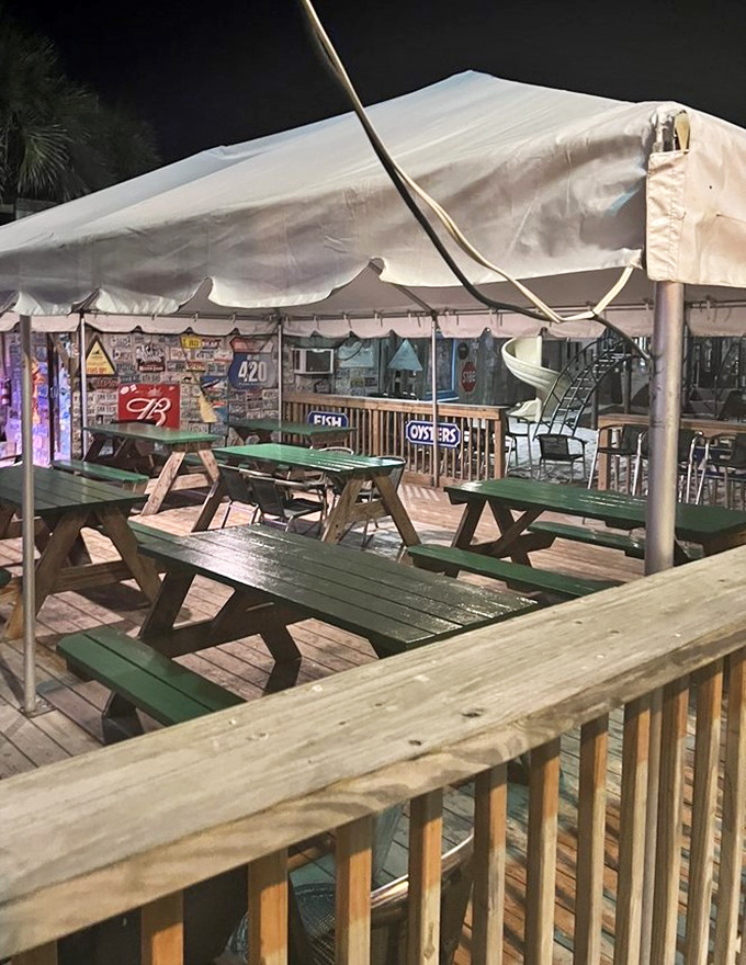 Outdoor seating under canvas shelter offers the quintessential beach dining experience &ndash; casual, breezy, and perfectly suited to enjoying Gulf Coast specialties.