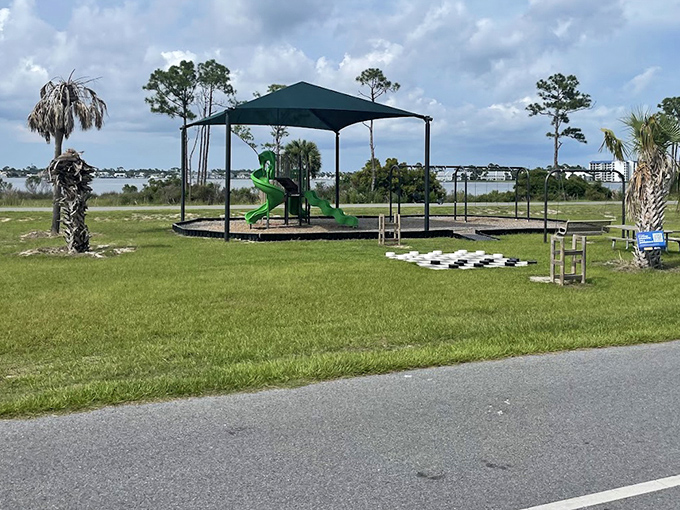 The playground stands ready for young adventurers, proving that even in nature's playground, sometimes kids need actual slides and swings.