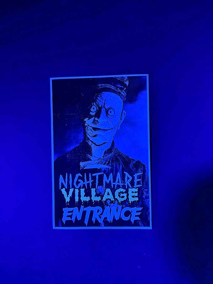 The Nightmare Village entrance poster serves as both invitation and warning. That face will haunt your dreams long after you've gone home.