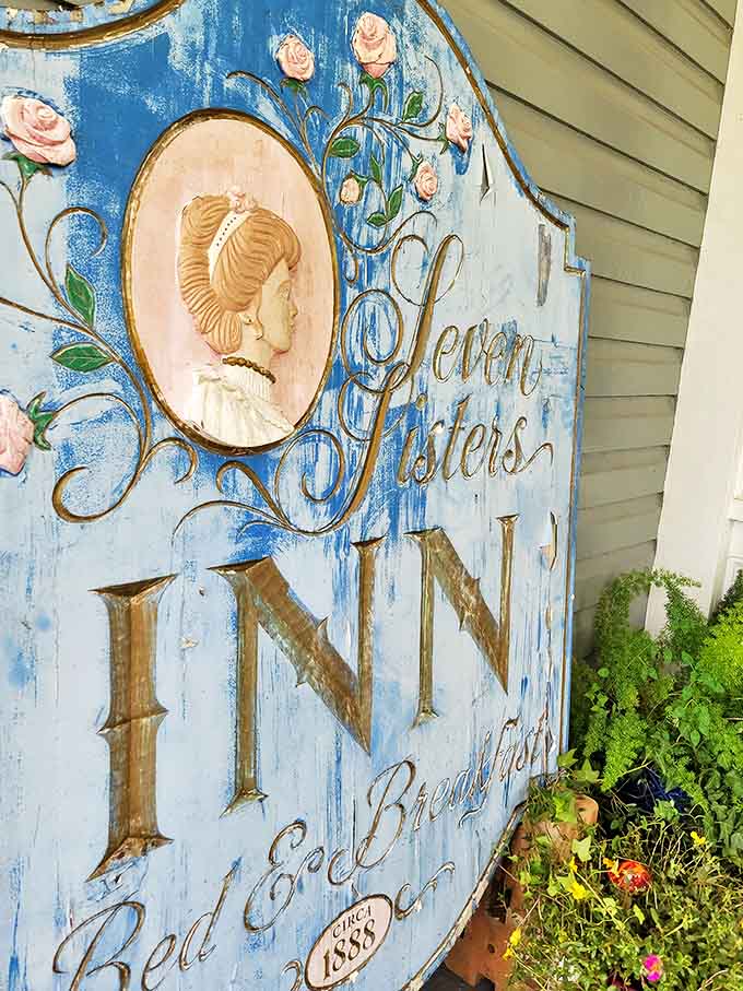The inn's weathered blue sign features a Victorian cameo portrait surrounded by roses, a fitting introduction to this historic treasure established in 1888.