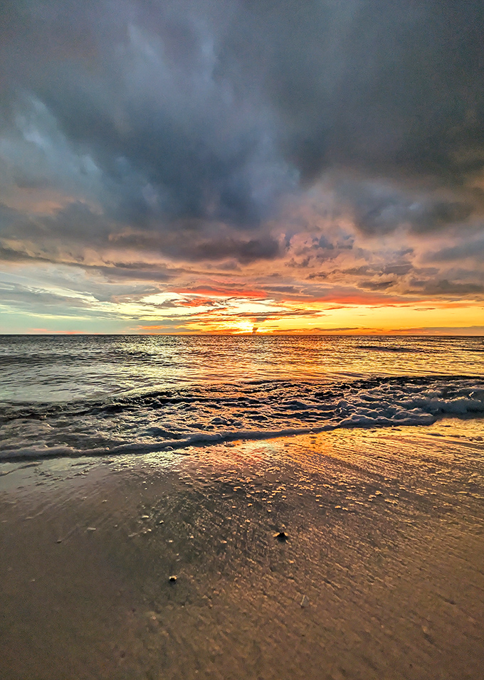 Sunset transforms Clam Pass into a canvas of liquid gold, where each gentle wave captures and reflects the day's final magnificent light show.