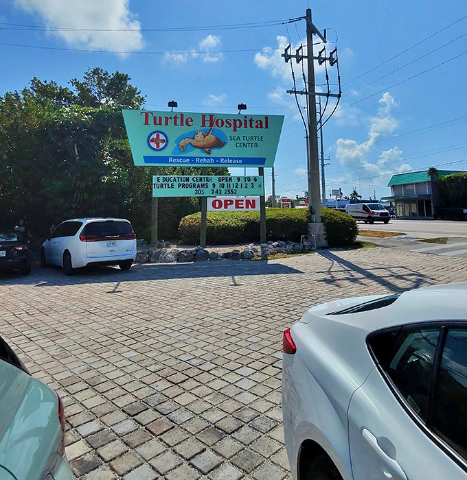 The roadside sign announces this unique attraction where entertainment meets education, inviting passersby to discover the remarkable work happening inside.