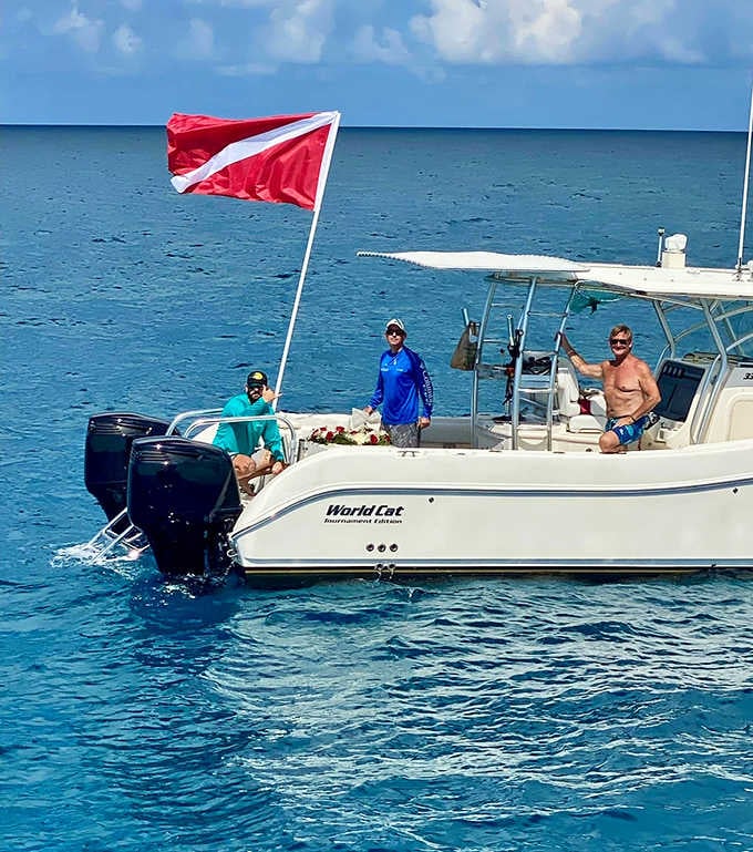 The dive flag signals underwater explorers below while the boat crew keeps watch over this unique cemetery excursion.