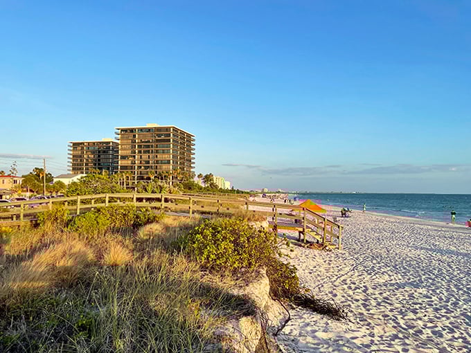 Beach access beckons through sea oats and dunes, with high-rises standing as modern lighthouses along the shore.
