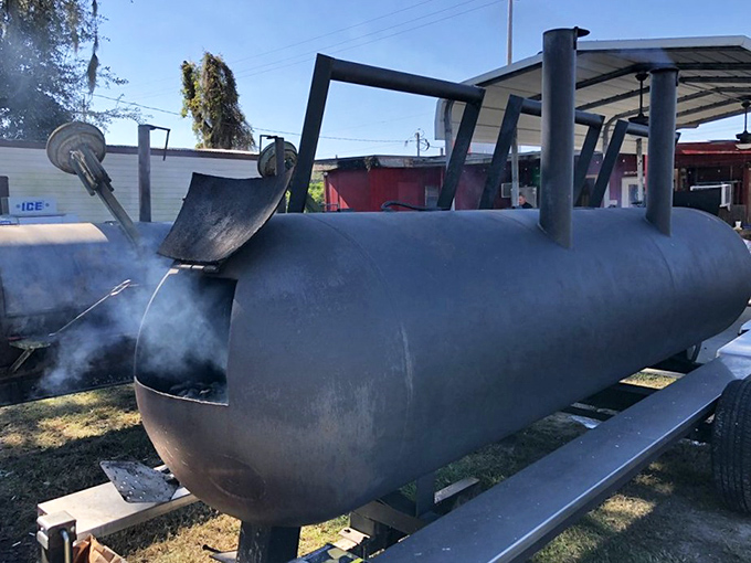 The massive cylindrical smoker works its low-and-slow magic outside, transforming ordinary meat into extraordinary barbecue all day long.