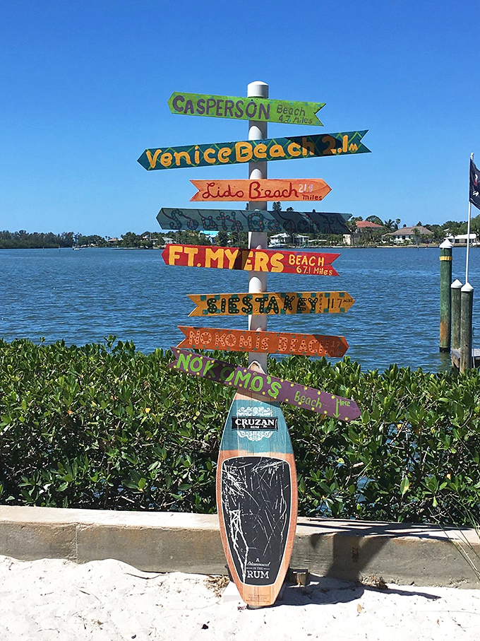 A whimsical directional sign points to nearby beaches, reminding visitors they're in paradise no matter which sandy path they choose.