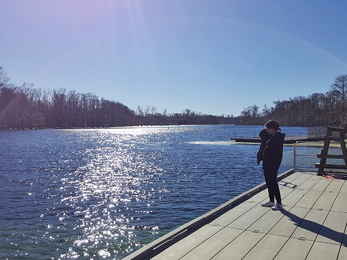 A solitary figure contemplates the sparkling waters from the dock &ndash; sometimes the best vacation moments happen in perfect stillness.